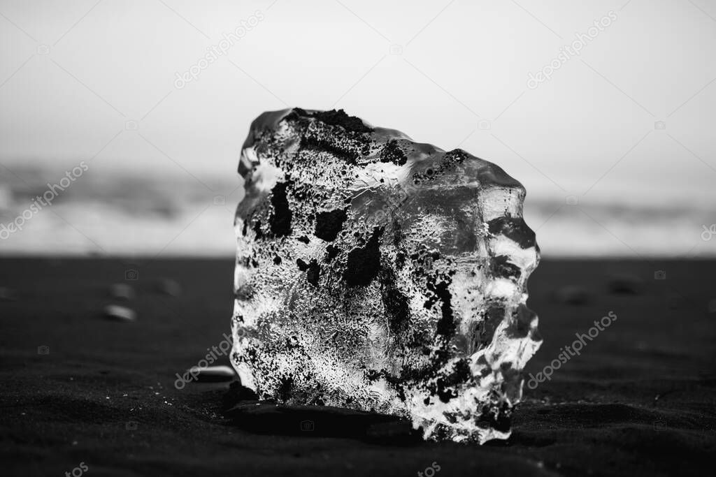 Trozo de glaciar cubierto de tierra negra yaciendo en la playa de arena ... Trozo de glaciar cubierto de tierra negra yaciendo en la playa de arena ...