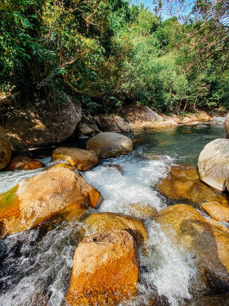 Un pequeño río de montaña fluye entre grandes piedras en áreas ...