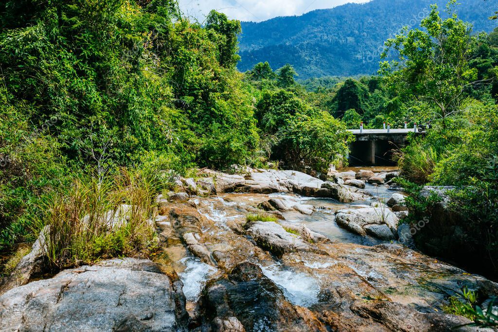 Un pequeño río de montaña fluye entre grandes piedras en áreas ...