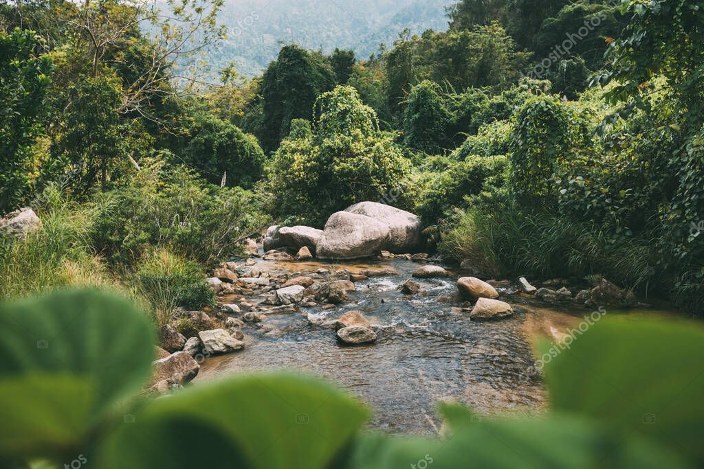 Un pequeño río de montaña fluye entre grandes piedras en áreas ...