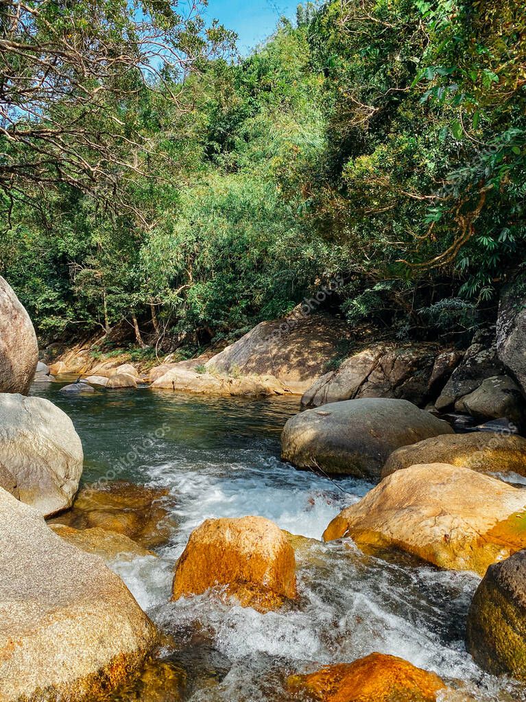 Un pequeño río de montaña fluye entre grandes piedras en áreas ...
