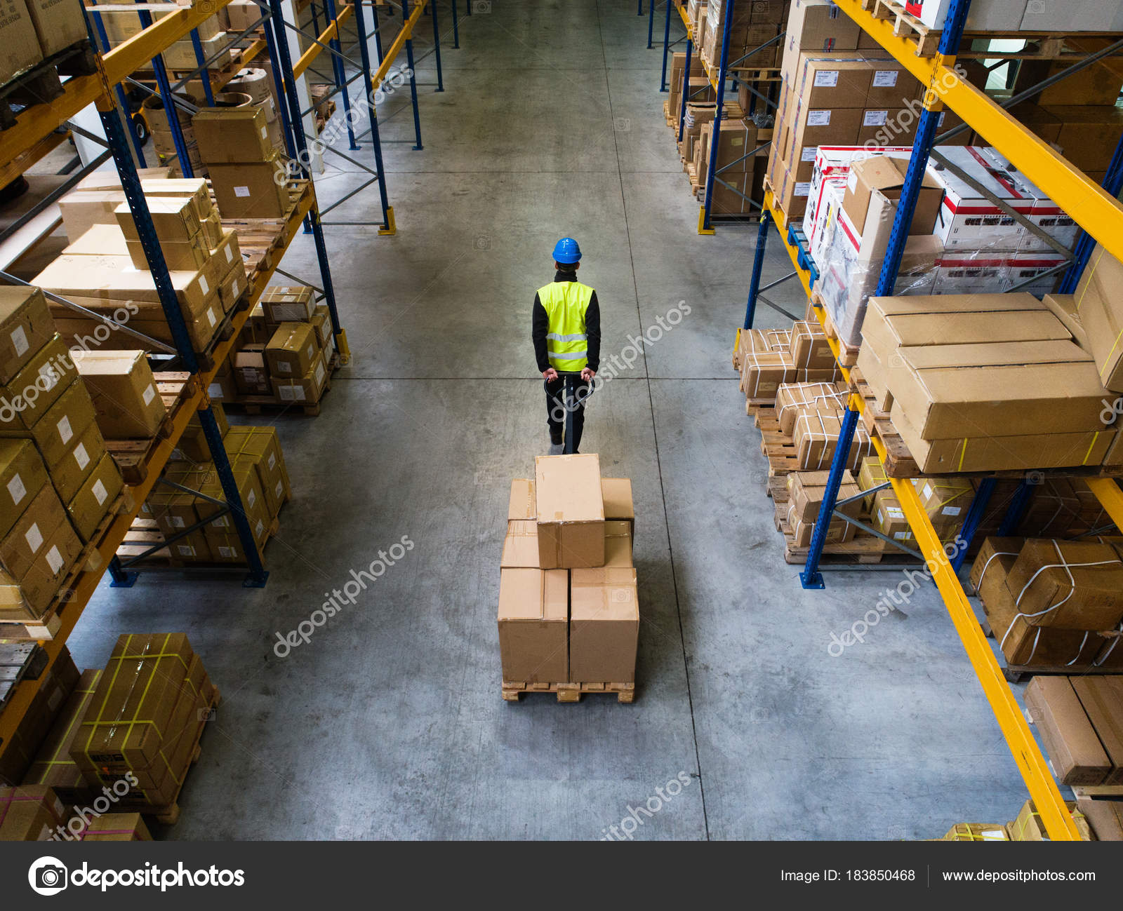 Hombre trabajador de almacén tirando de una transpaleta .: fotografía ...