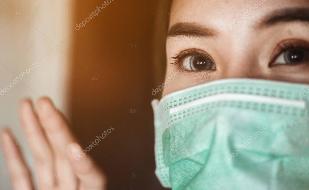La mujer que usa protección antifaz en la ventana espera a que la ...