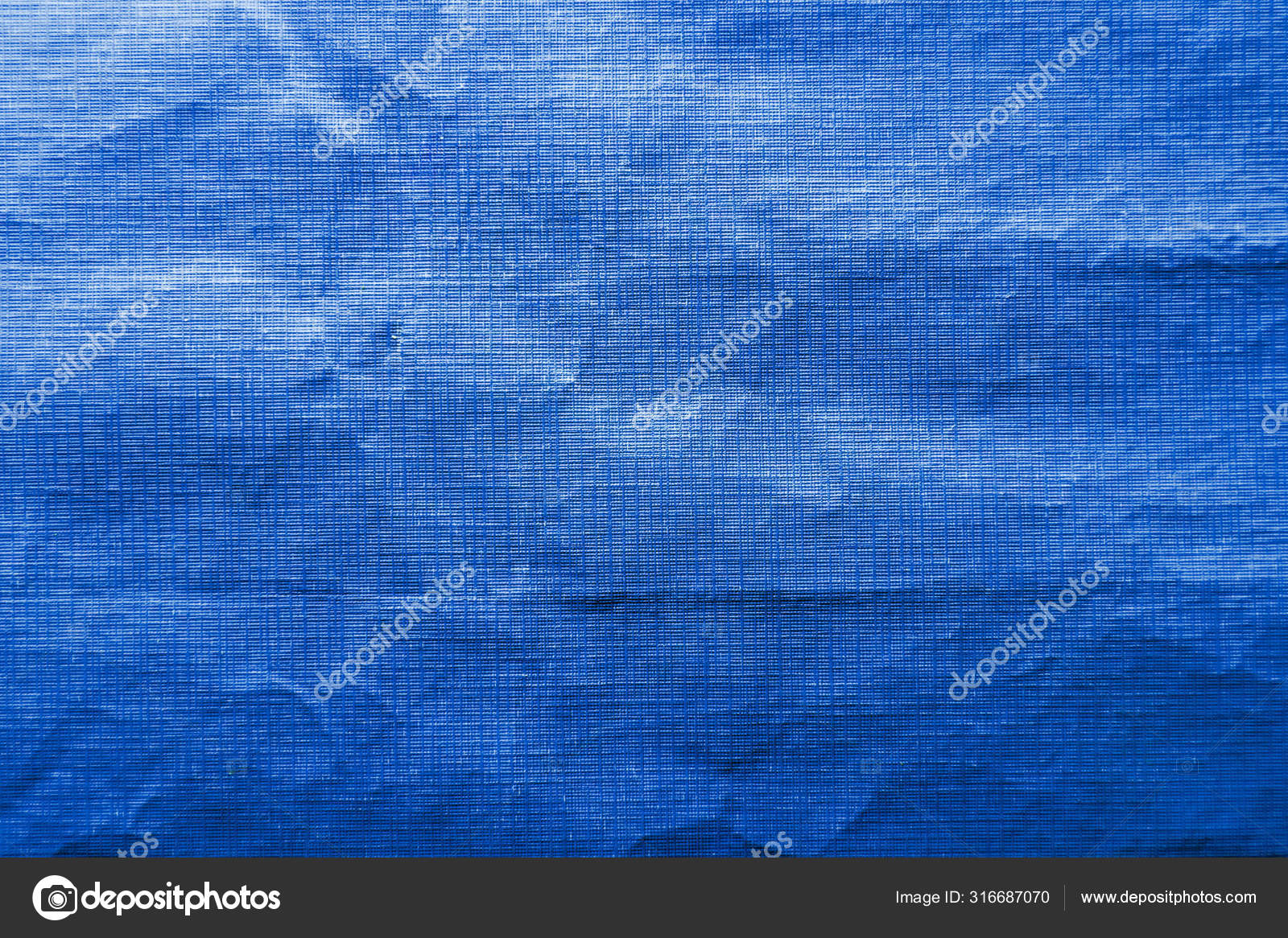 Dirty crumpled blue synthetic fabric texture with a well-traced light ...