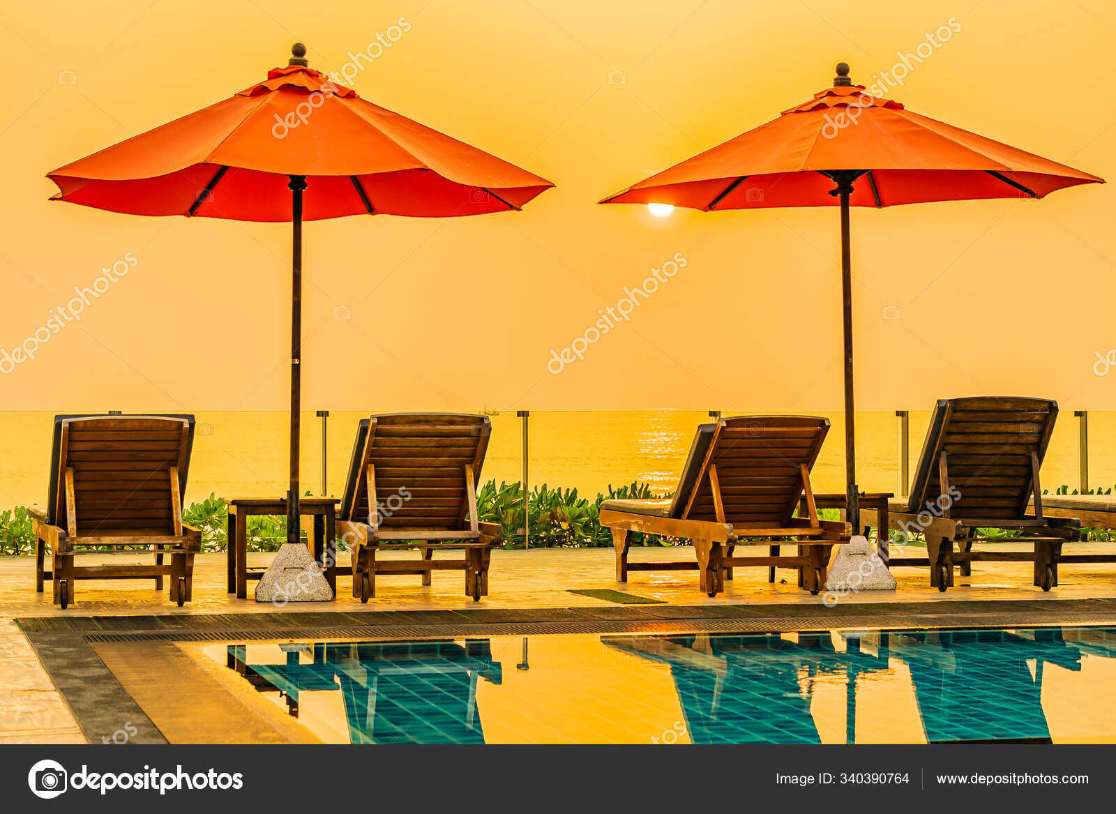 Beautiful sunrise around with umbrella and chair outdoor swimmin ...