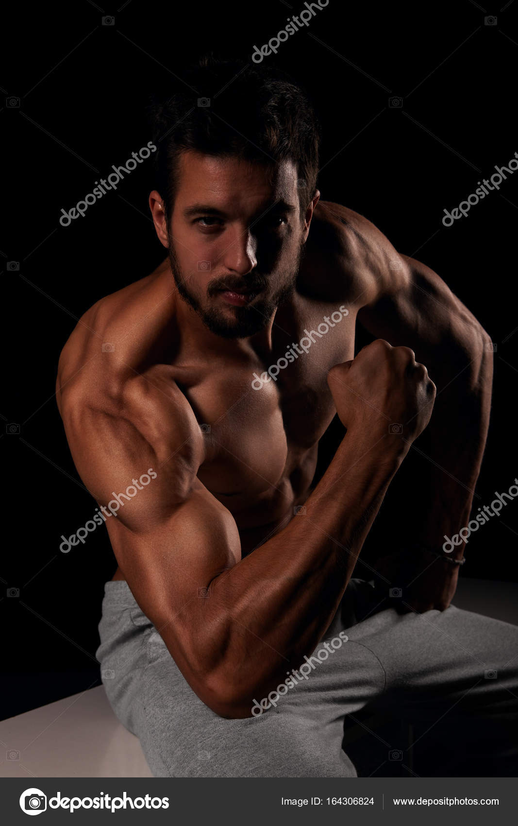Handsome male model posing and showing his arm muscles Stock Photo by ...