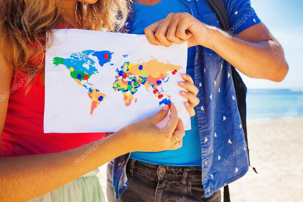 Couple holding map on beach Stock Photo by ©apid 128074342