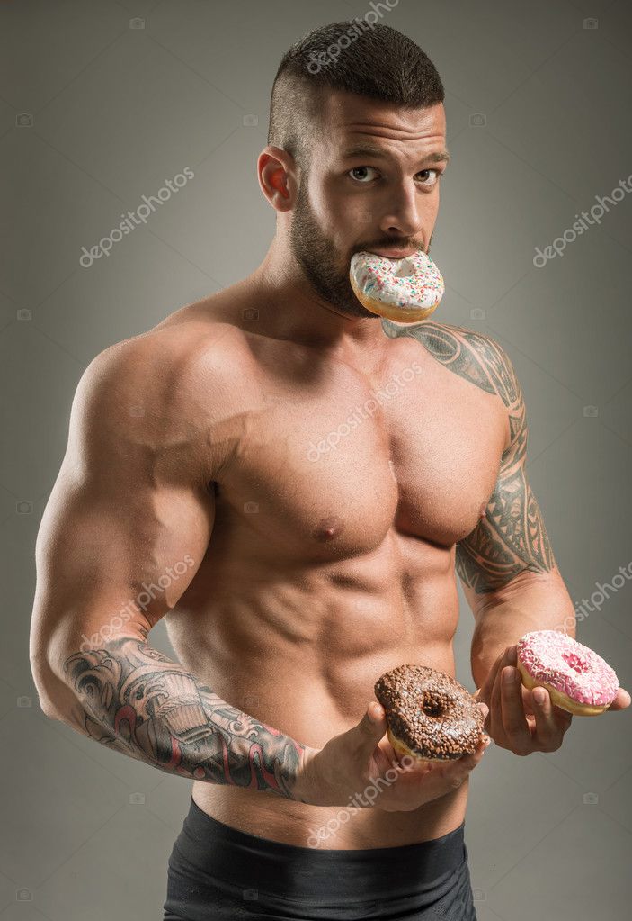 Muscular man holding donuts Stock Photo by ©Geribody 125884936