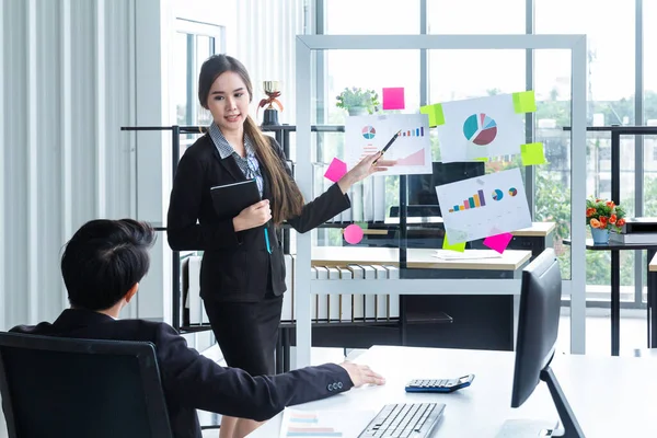 Young businesspeople analyzing information through computers and ...