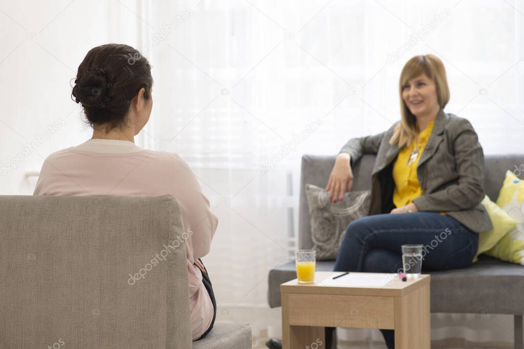 Dos mujeres teniendo una conversación informal sentadas en un sofá en ...