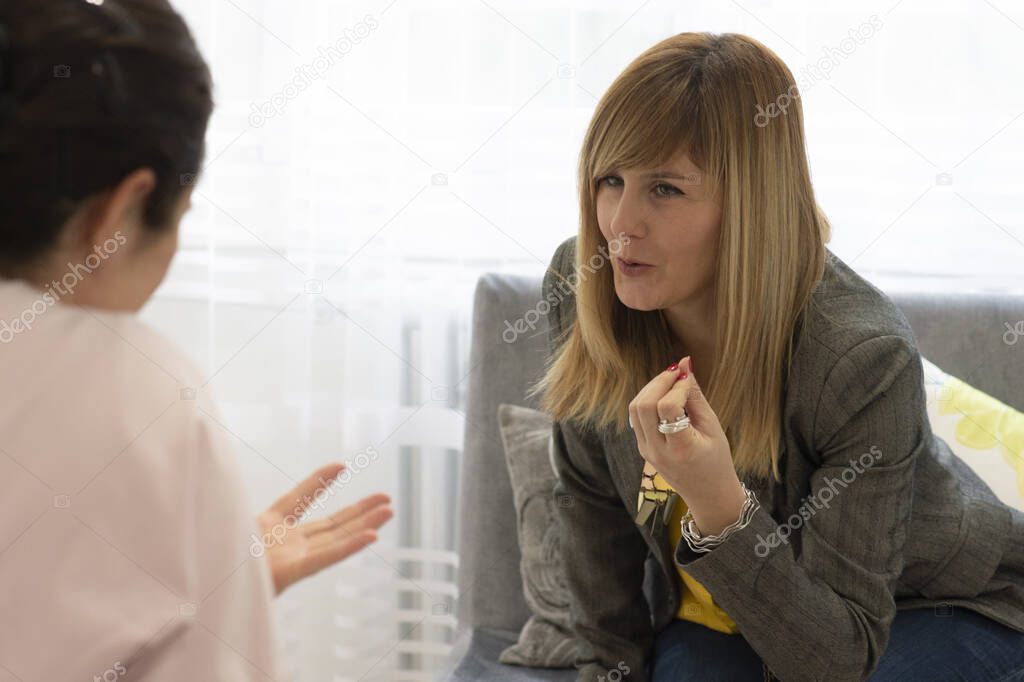 Dos mujeres teniendo una conversación informal sentadas en un sofá en ...