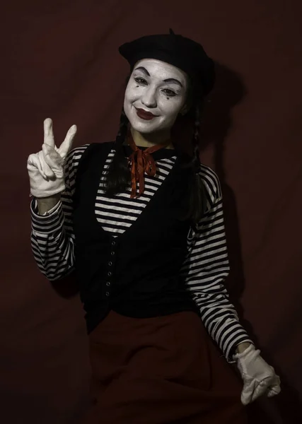 Beautiful girl mime smiles and makes a gesture of a beating heart with ...