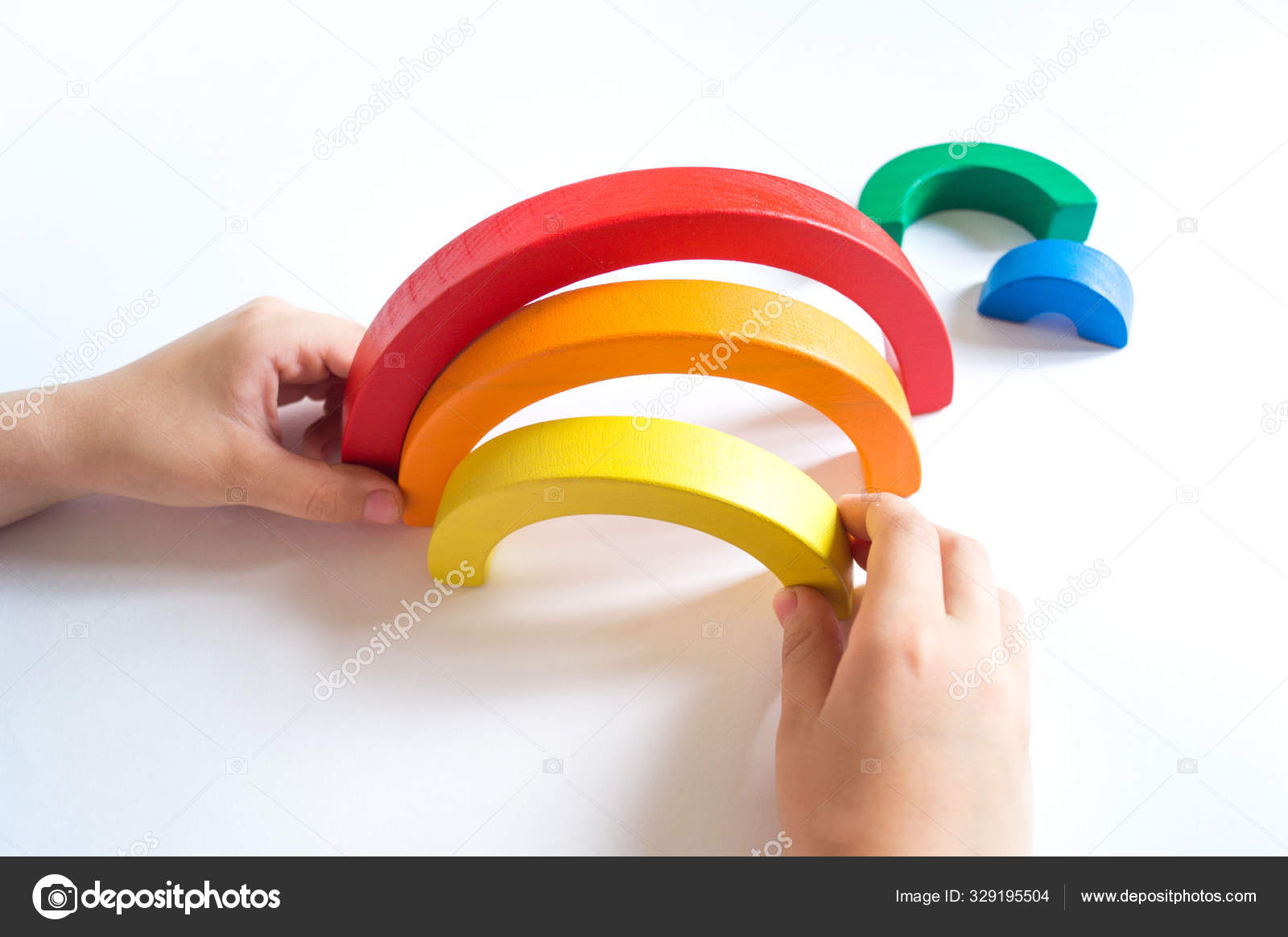 Montessori wood rainbow material. A child plays with a toy with his ...