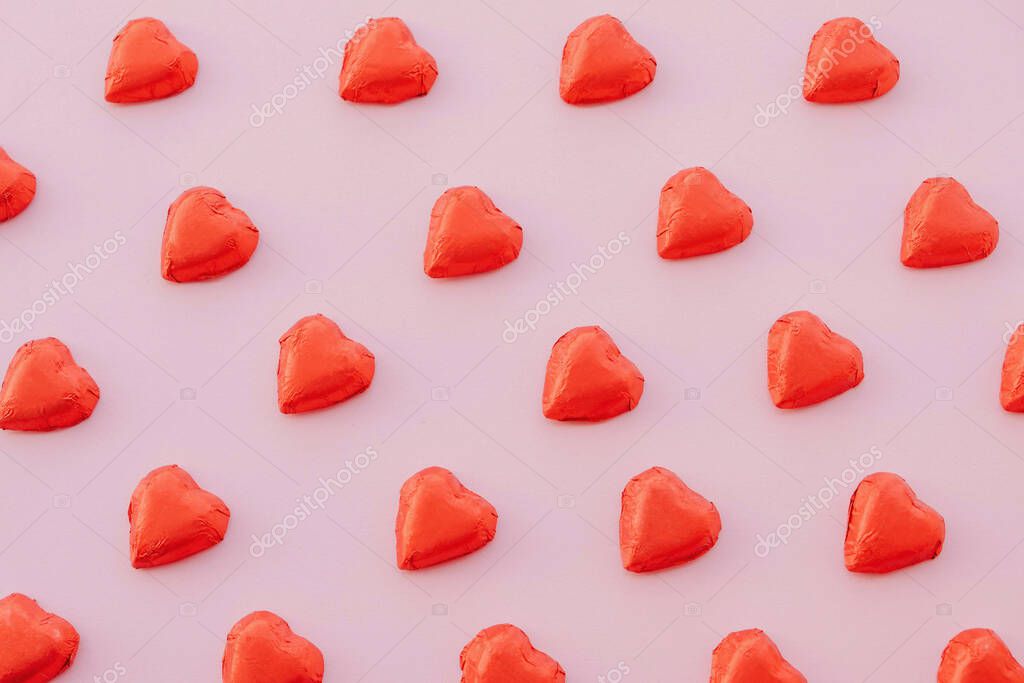 Patrón de bombones dulces rojos en forma de corazón sobre fondo rosa ...