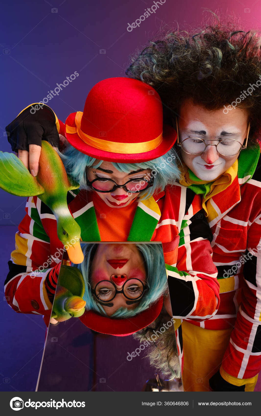 Two clowns a man and a woman with bright makeup in colored costumes say ...