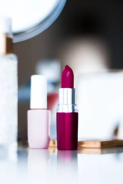 Cosmetics, makeup products on dressing vanity table, lipstick, f ...