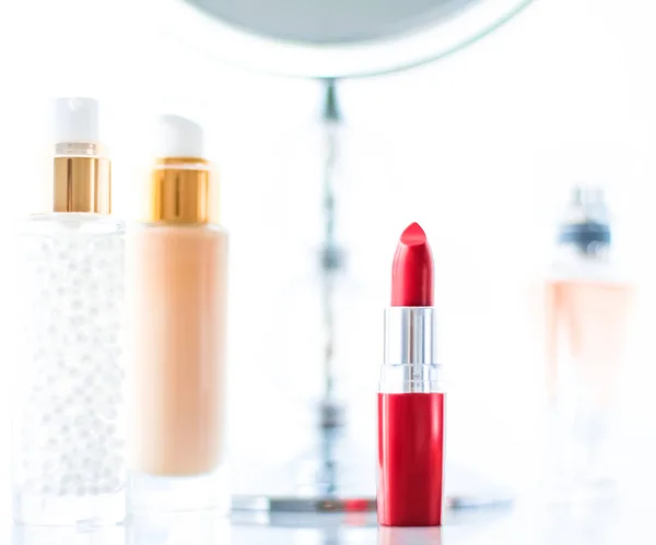 Cosmetics, makeup products on dressing vanity table, lipstick, f ...