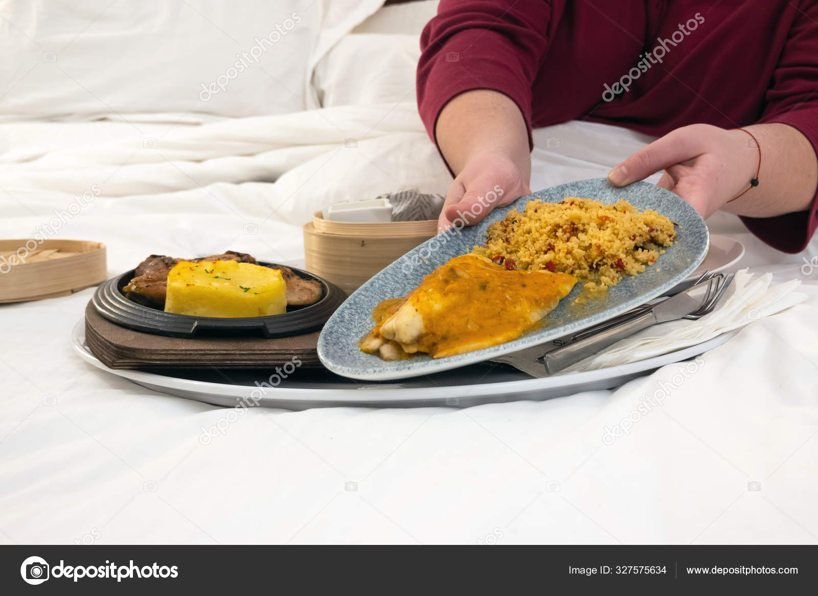 Room service food on the bed in a hotel room. Woman enjoying luxurious ...