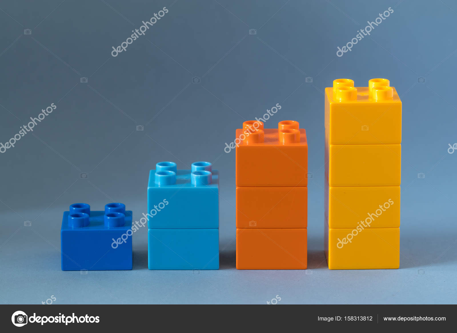 Growing bar chart from color toy blocks on blue background. Stock Photo ...