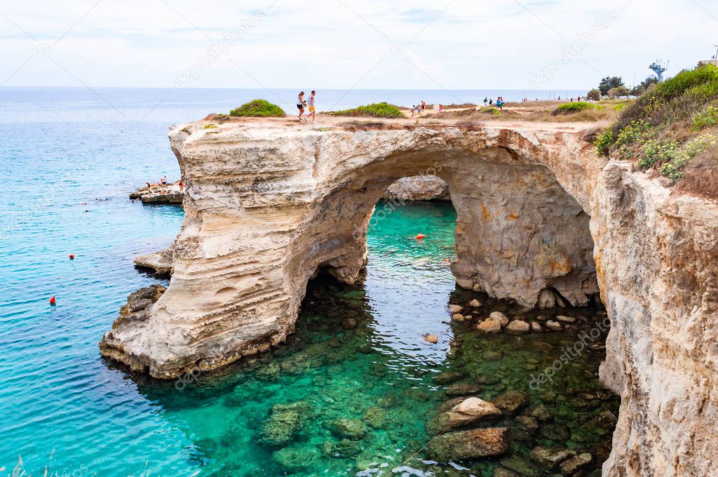 Turistas en el borde de la roca. Playa Torre Sant Andrea con sus suaves ...