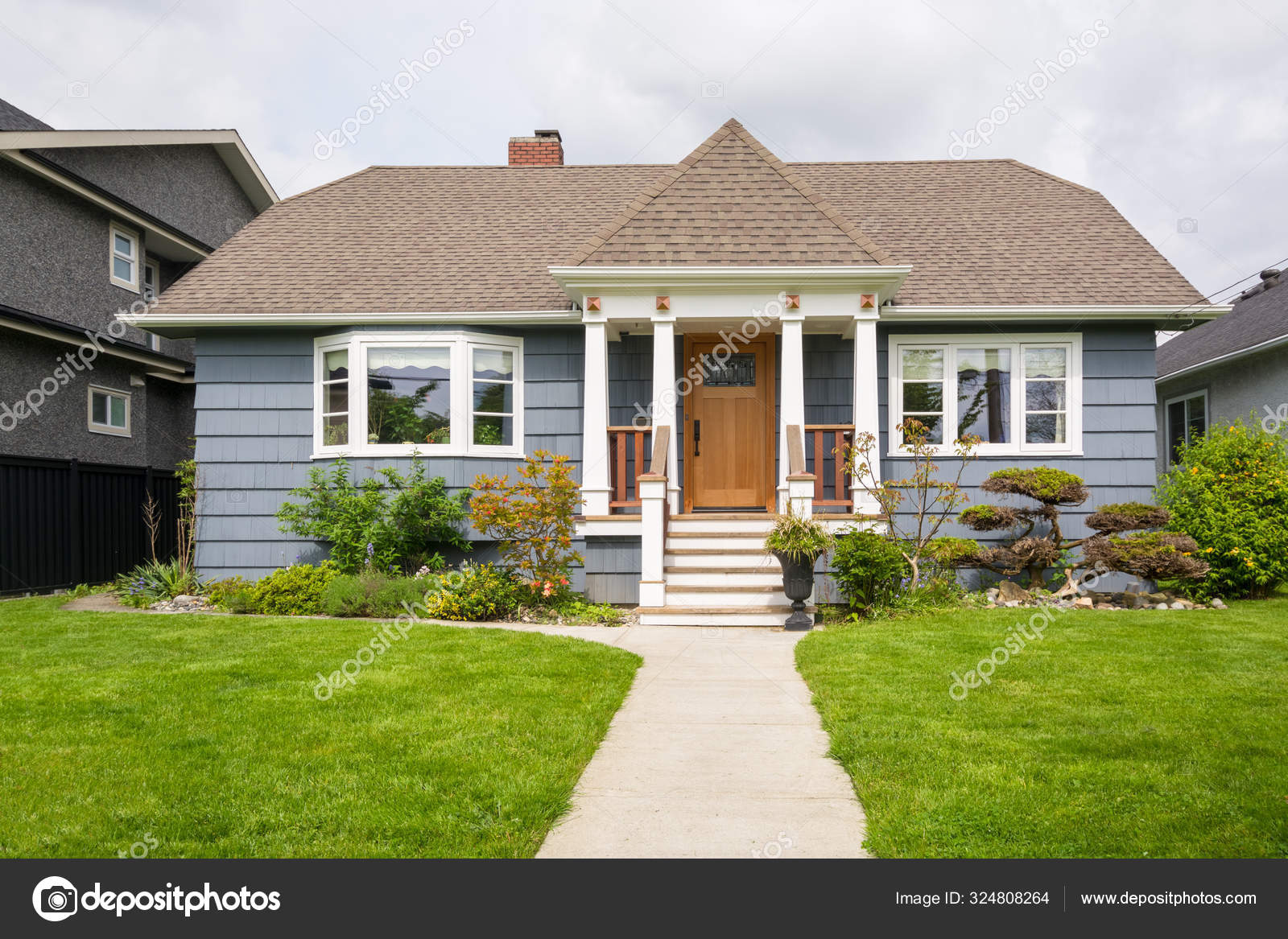 Average residential house with concrete pathway to the main entrance ...