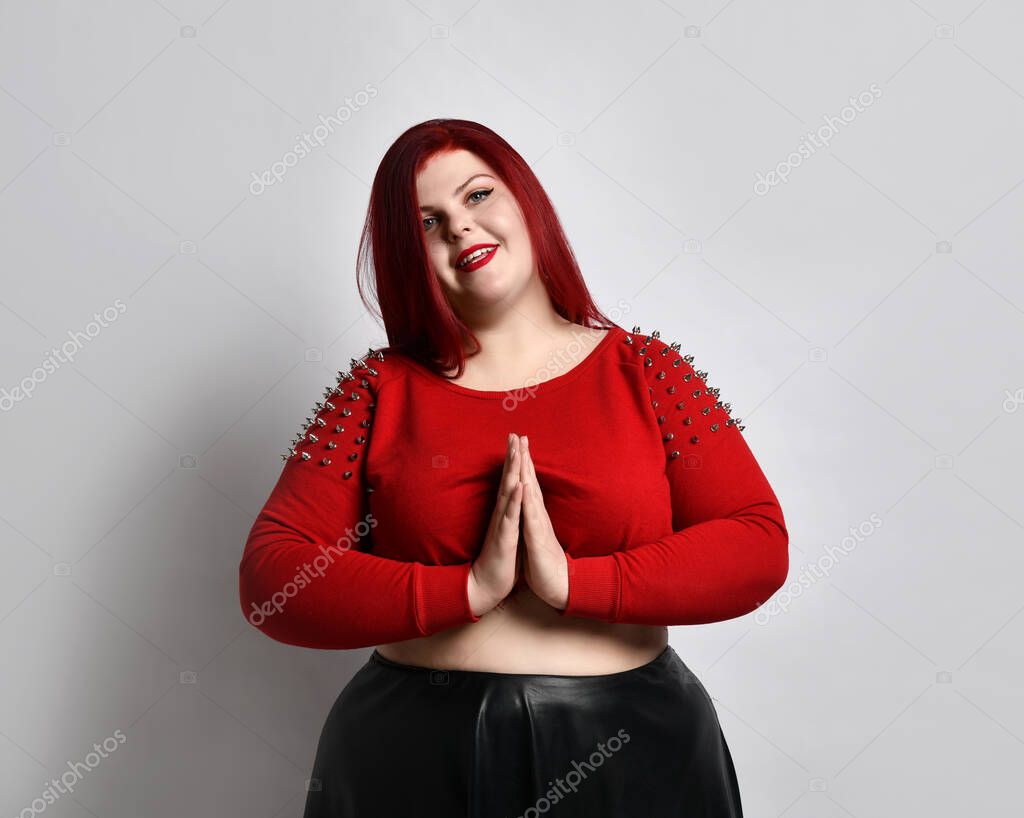 Mujer pelirroja con sobrepeso en top con pinchos rojos, falda de cuero ...