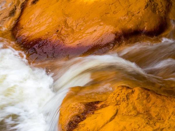 Smooth flowing water falling over rocks - Stock Image - Everypixel