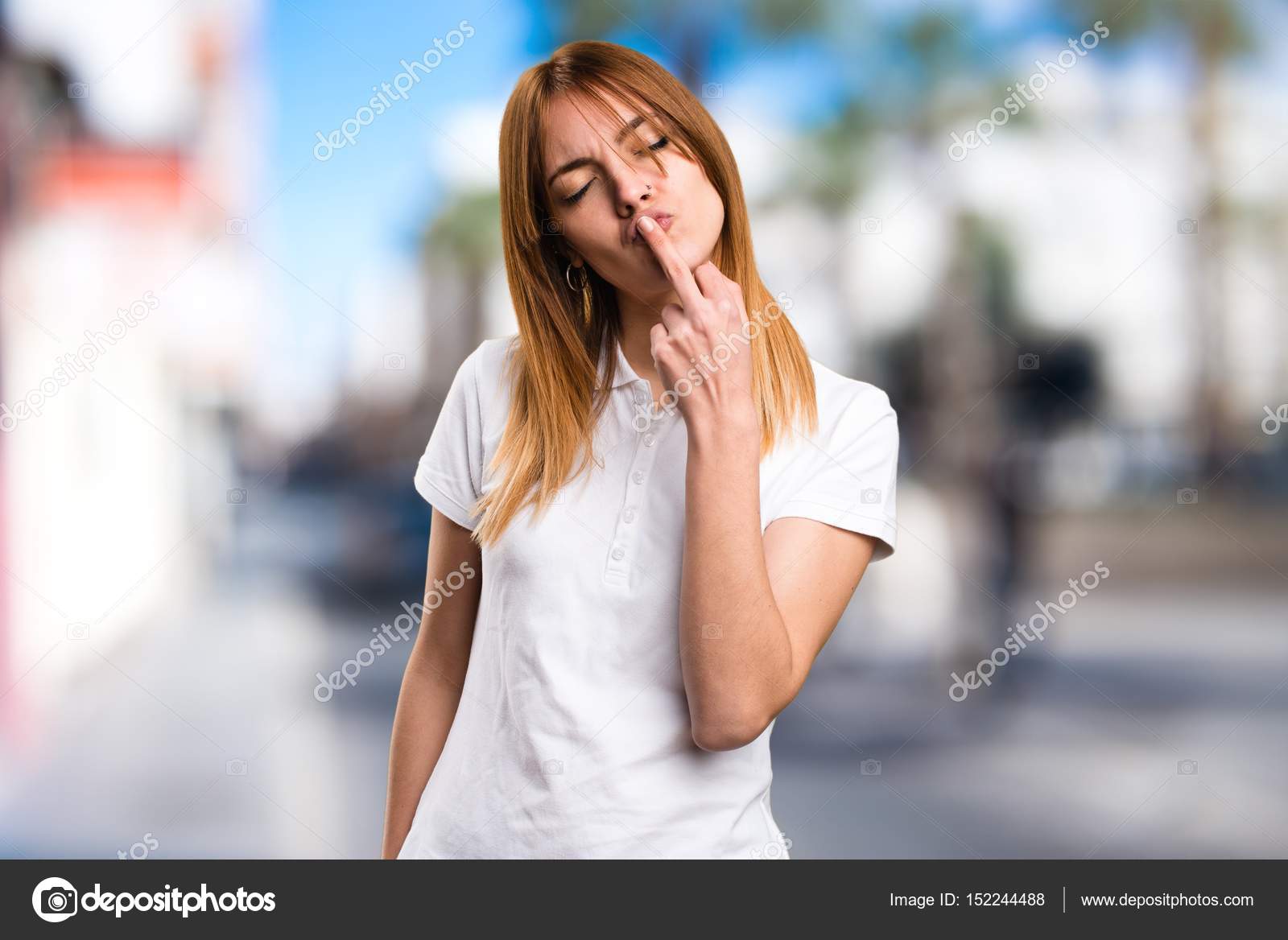 Beautiful young girl making horn gesture on unfocused background Stock ...