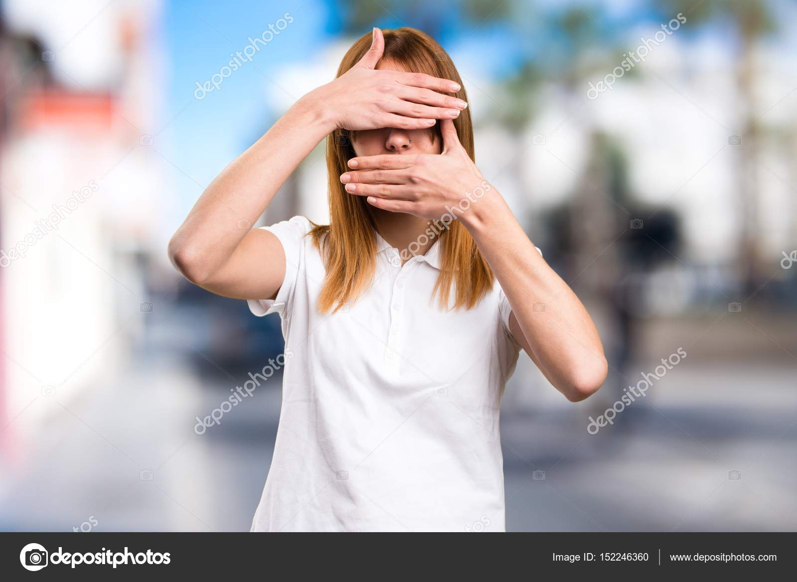 Beautiful young girl covering her face on unfocused background Stock ...
