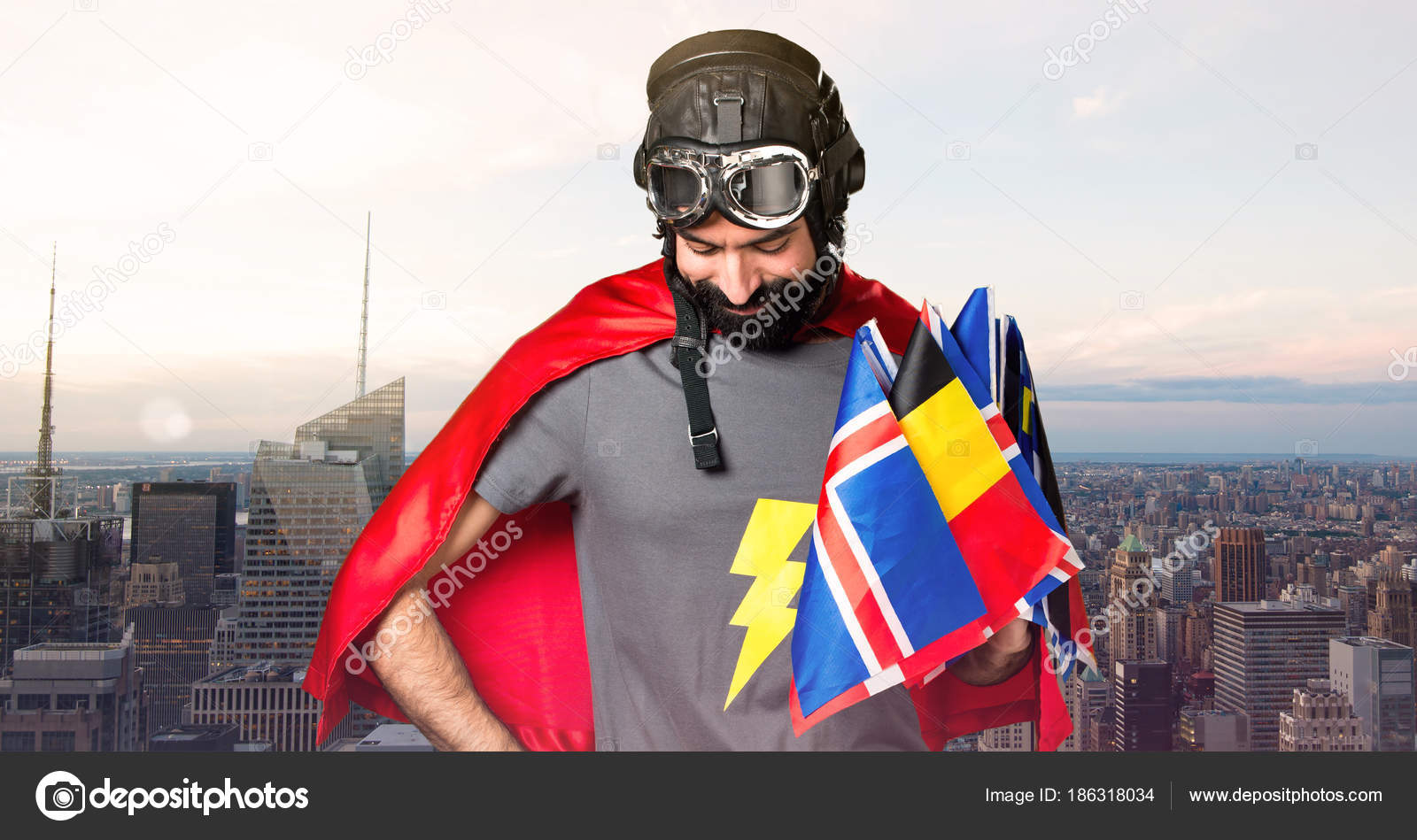Superhero with a lot of flags looking down on unfocused city bac ...