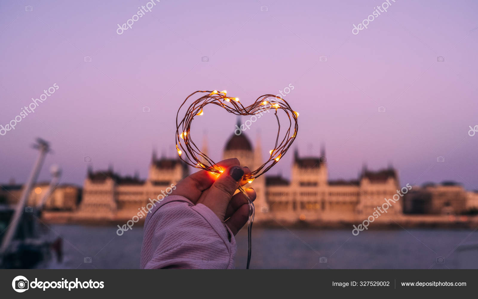 Heart from lights at the background of Parliament building of Budapest ...