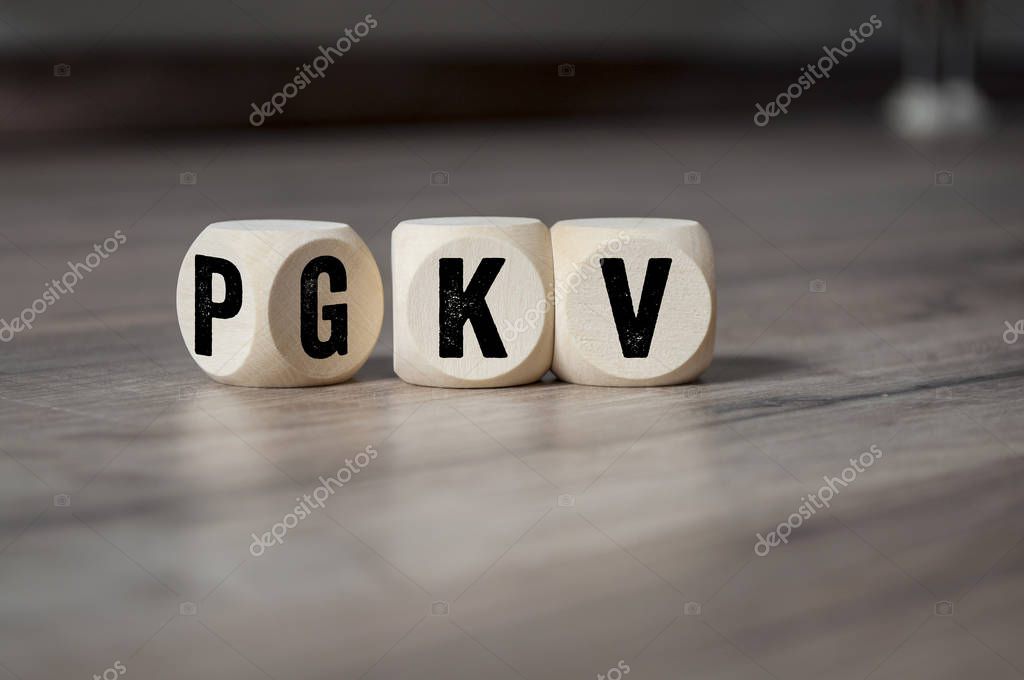 Cubos y dados con las siglas PKV y GKV sobre fondo de madera 2024