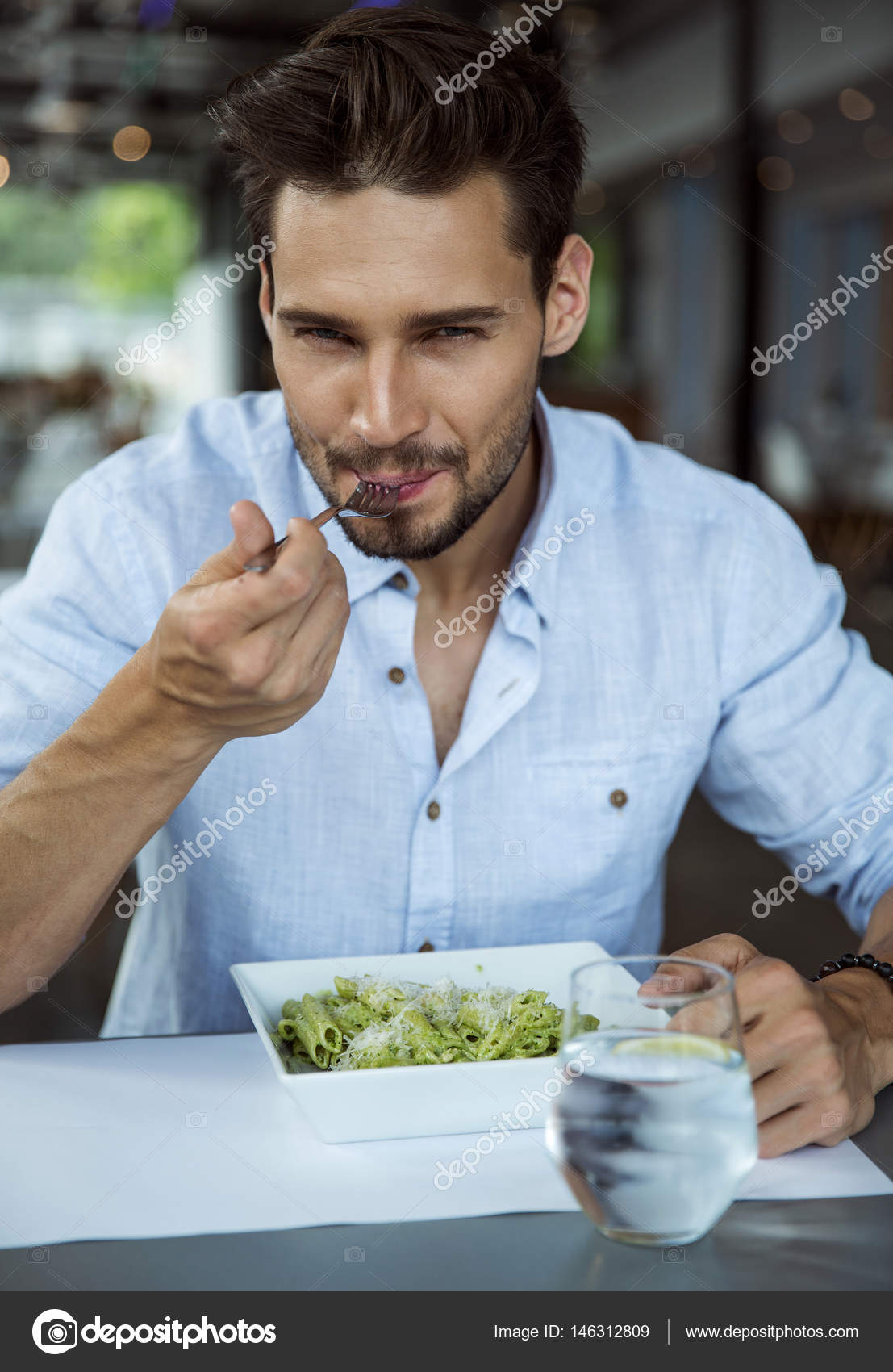 Handsome man eating pasta Stock Photo by ©kiuikson 146312809