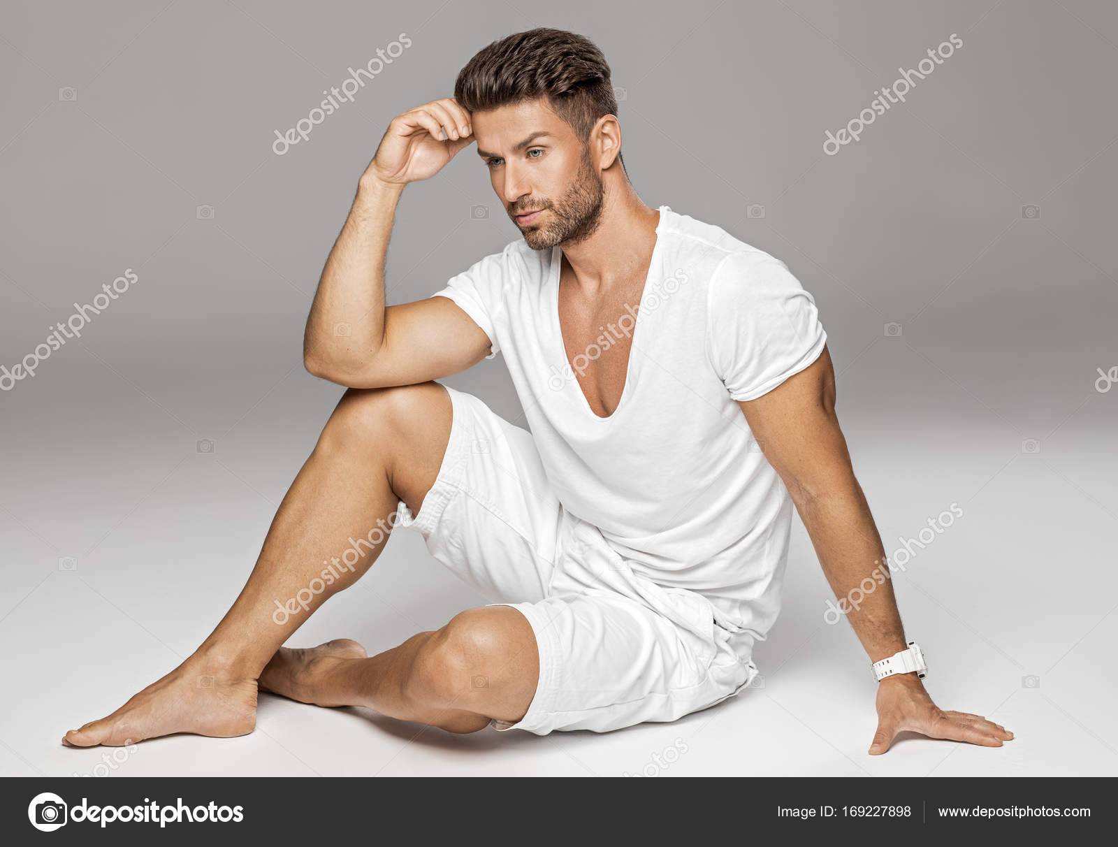 Male model in white sitting Stock Photo by ©kiuikson 169227898