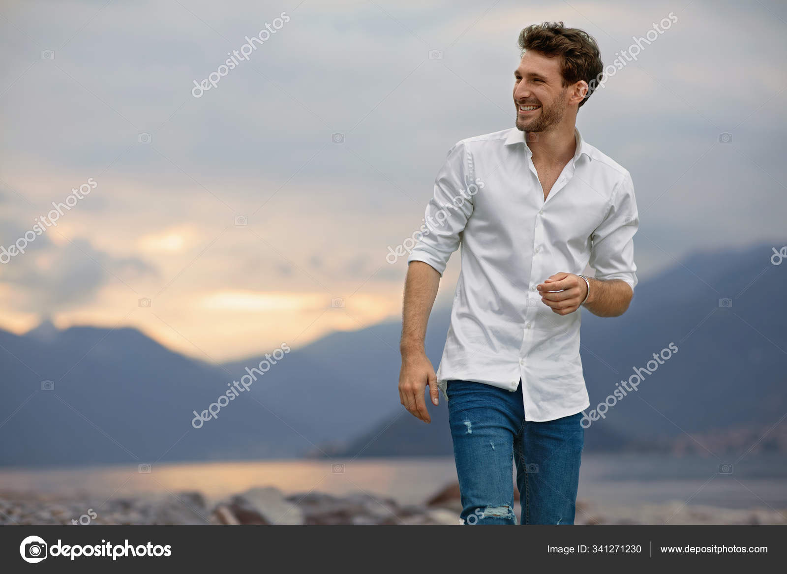 Smiling male model standing on a background of lake and mountain Stock ...