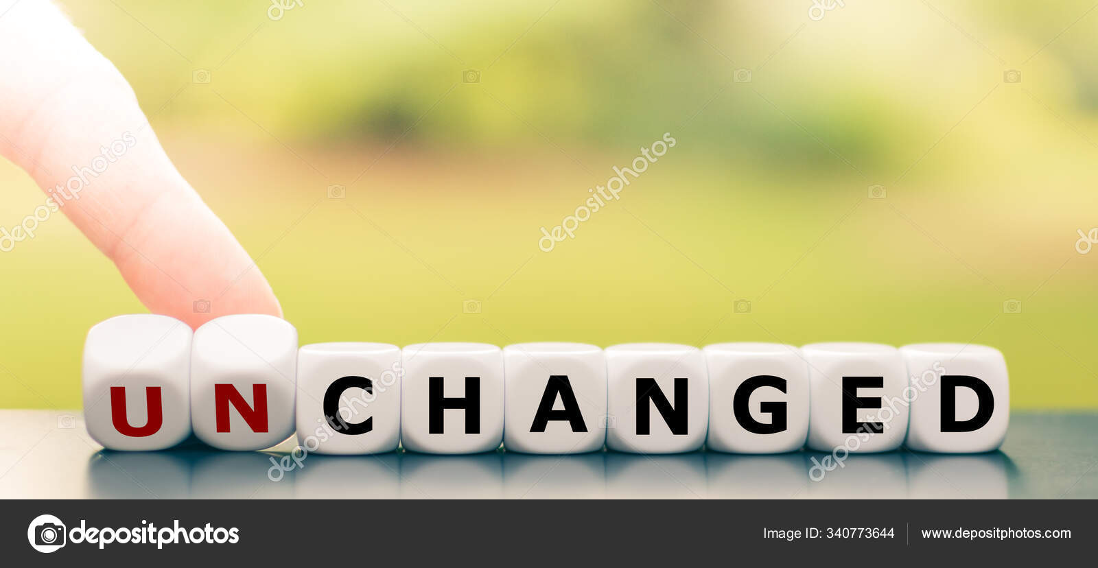 Hand turns dice and changes the word "unchanged" to "changed". Stock ...