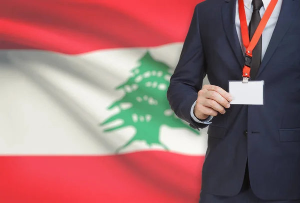 Businessman holding name card badge on a lanyard with a national flag ...