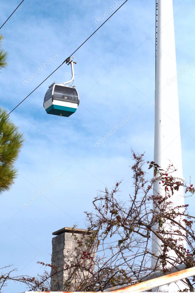 Pequeñas cabañas funiculares eléctricas en el cielo azul sobre el paseo ...