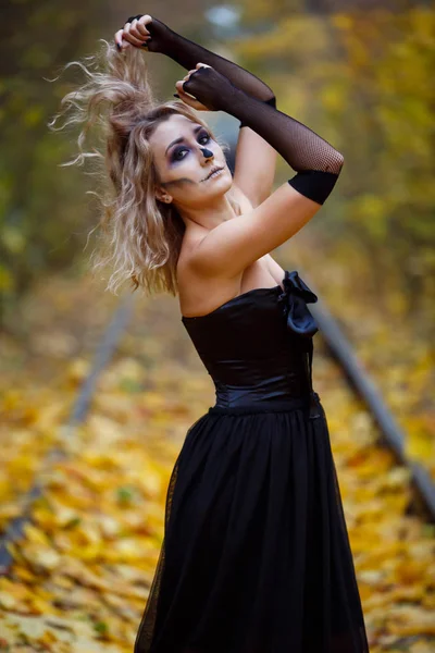 A woman is wearing skeleton makeup on her face for a Halloween ...