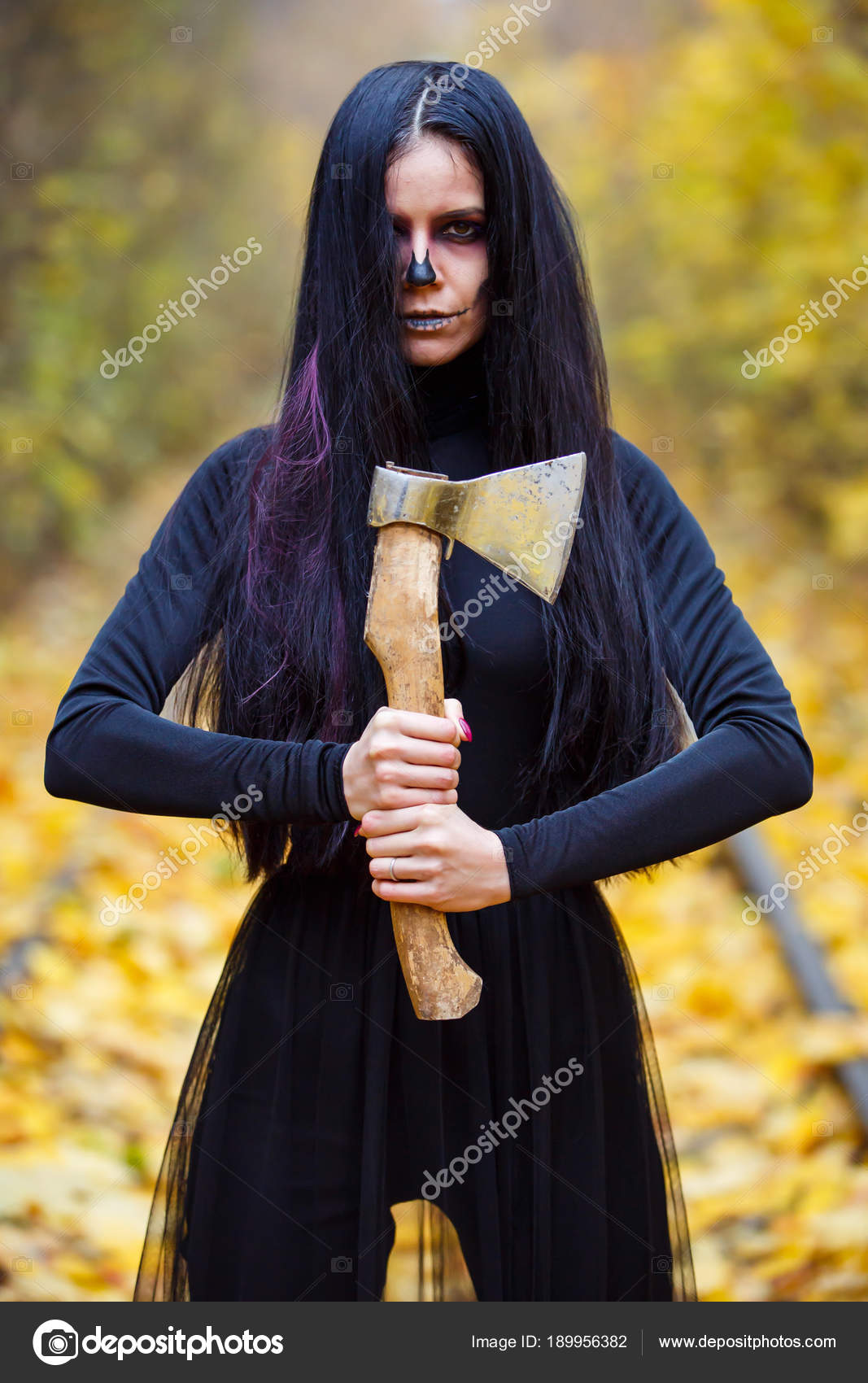 Beautiful girl with big massive ax in her heand. Creative make-up ...