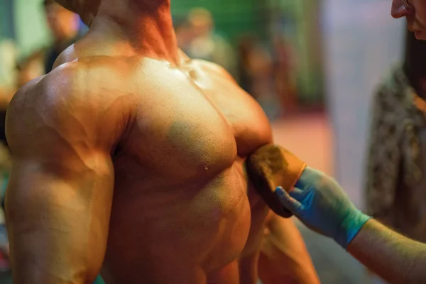 Bodybuilding competition backstage: contestant being oiled and fake tan ...