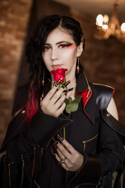 A gothic prince, a vampire, a demon a man and holds a rose in his hands ...