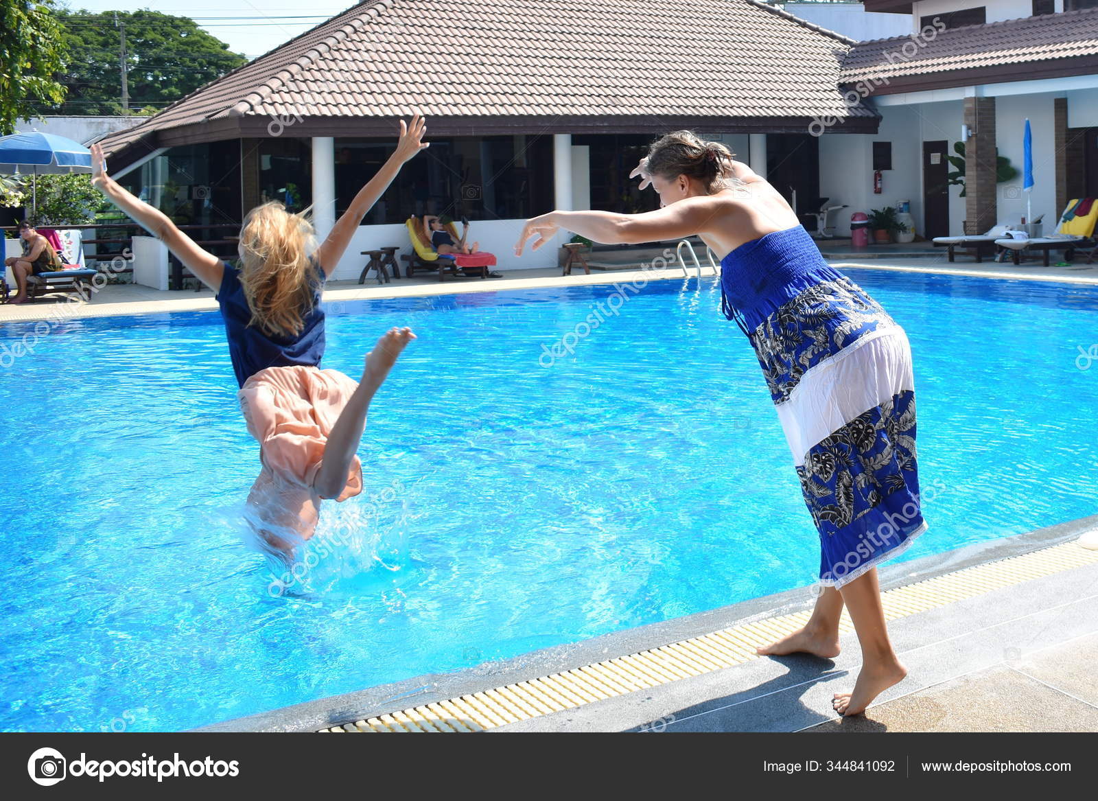 Fooling around by the pool. Girlfriend having fun on vacation. Padania ...