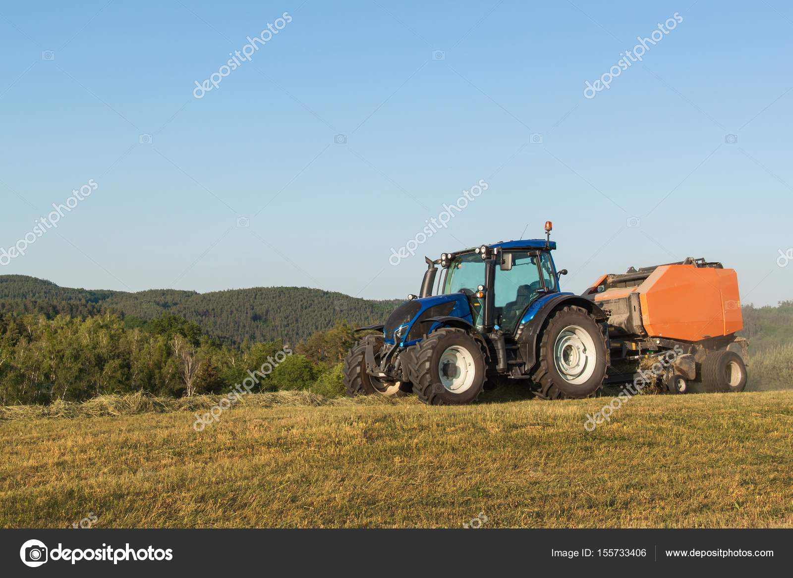 Blue tractor on the pasture.. Agricultural work on the farm in the ...