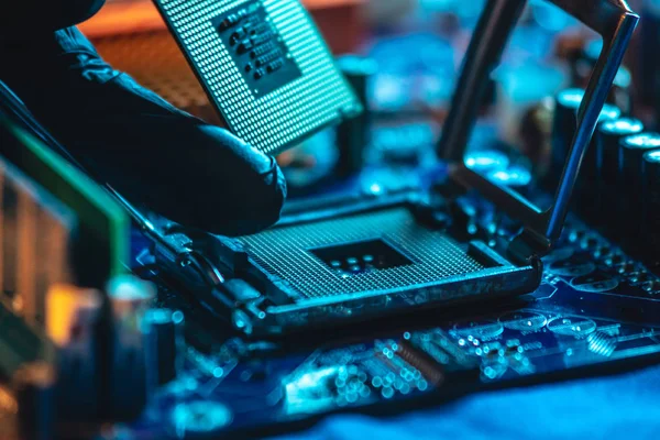 Repairman holding hands CPU to insert into the socket of the mot ...