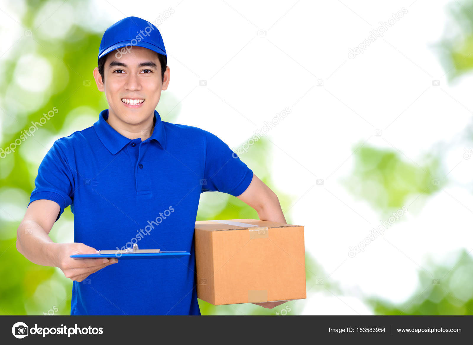 Smiling delivery man giving clipboard while holding box Stock Photo by ...