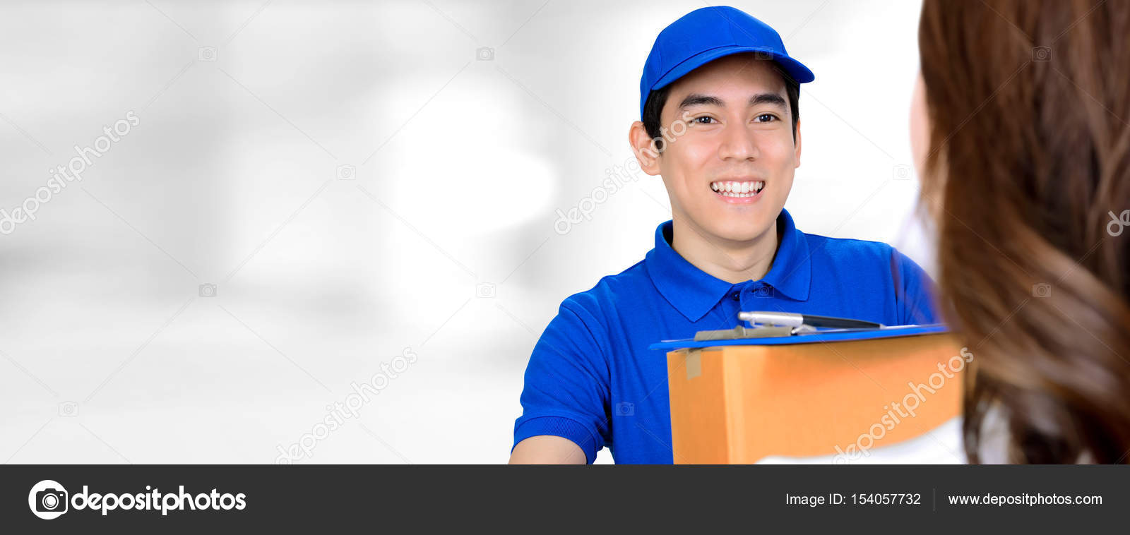 Smiling delivery man delivering a package Stock Photo by ©kritchanut ...