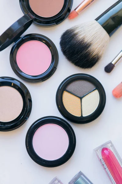 Makeup and makeup brushes on the table. Eye shadow, lipstick, gloss ...