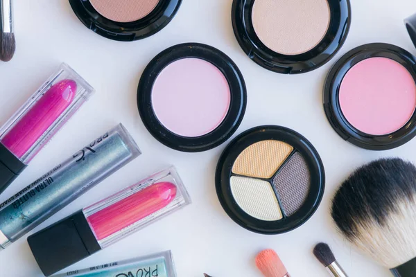 Makeup and makeup brushes on the table. Eye shadow, lipstick, gloss ...