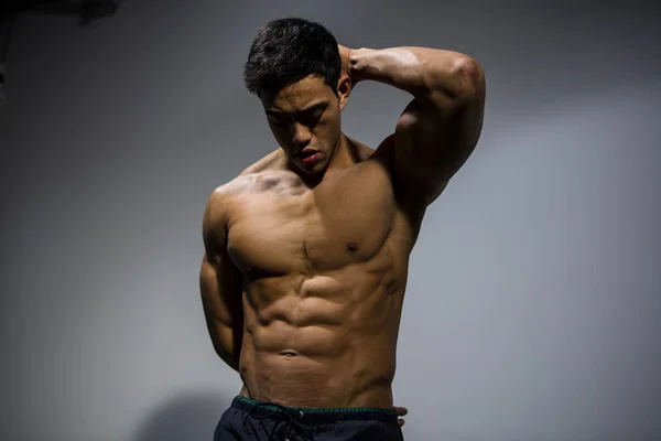 Asian Fitness Model Flexes Muscular Abdomen - Stock Image - Everypixel